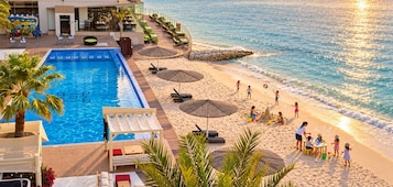 Resort com piscina, área de praia e área de estar ao ar livre.