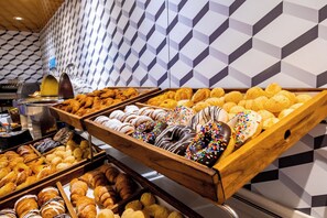 Vitrine de pastelaria com diversos doces e donuts.