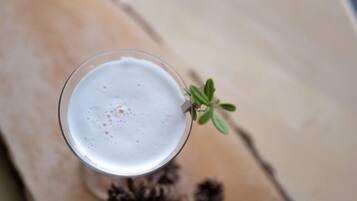 Um copo de bebida branca com um enfeite sobre uma superfície de madeira.