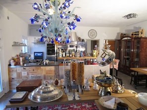 Uma cozinha com uma luminária azul de vidro decorativa, um armário de madeira e diversos eletrodomésticos.