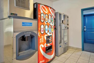 Máquina automática com o logotipo da Coca-Cola, um dispensador de água e um aviso para não encher recipientes para gelo.