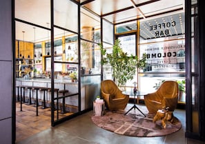 Um café moderno com assentos, balcão e uma grande janela com vista para a cidade.