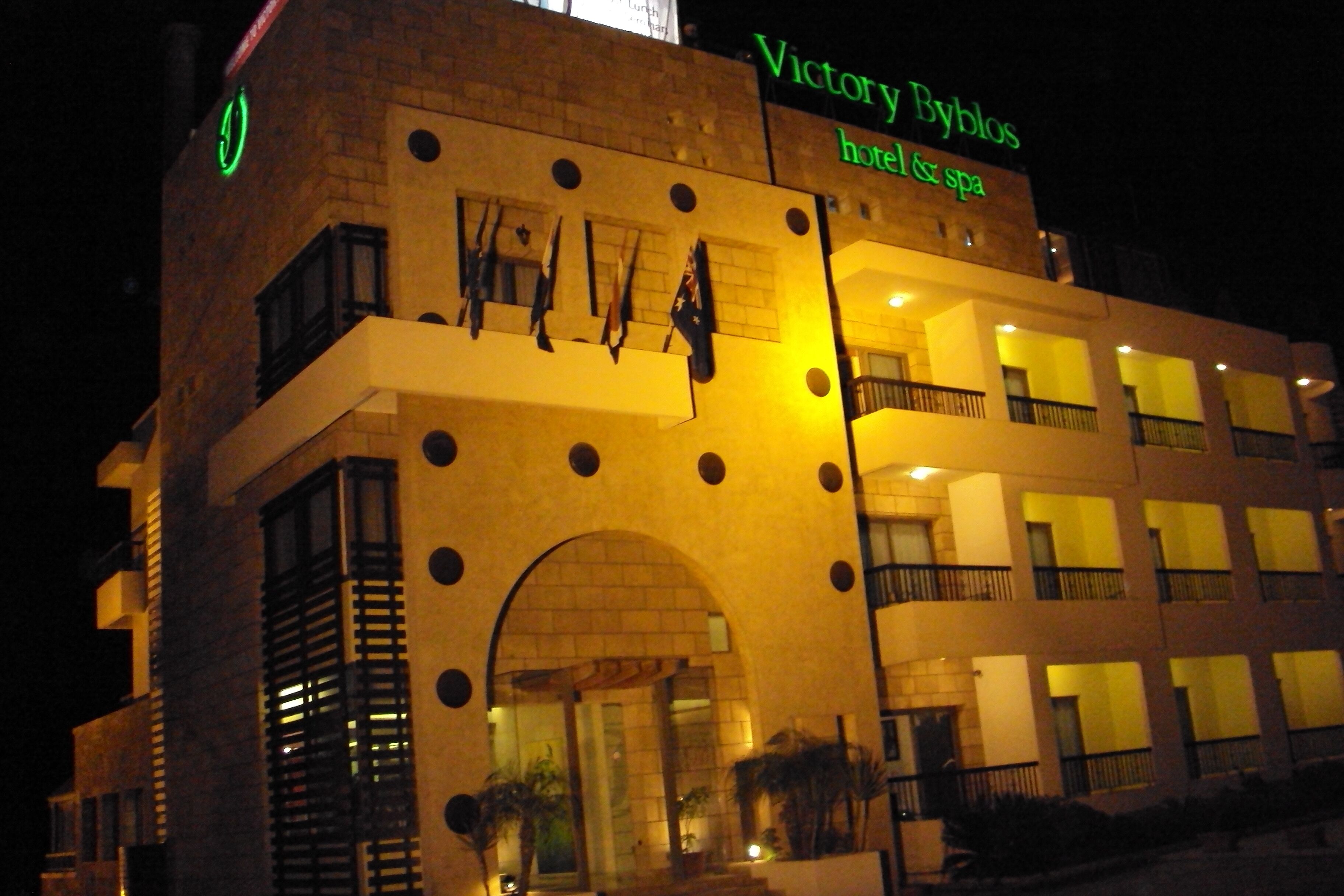 Um hotel com fachada moderna, apresentando uma arcada imponente e várias varandas.