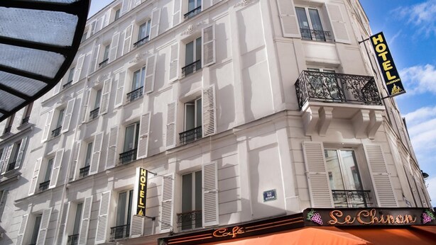 Um hotel com fachada clássica, várias varandas e um letreiro de café.