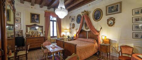 Um quarto tradicional com uma cama de dossel, um candelabro e decoração clássica.