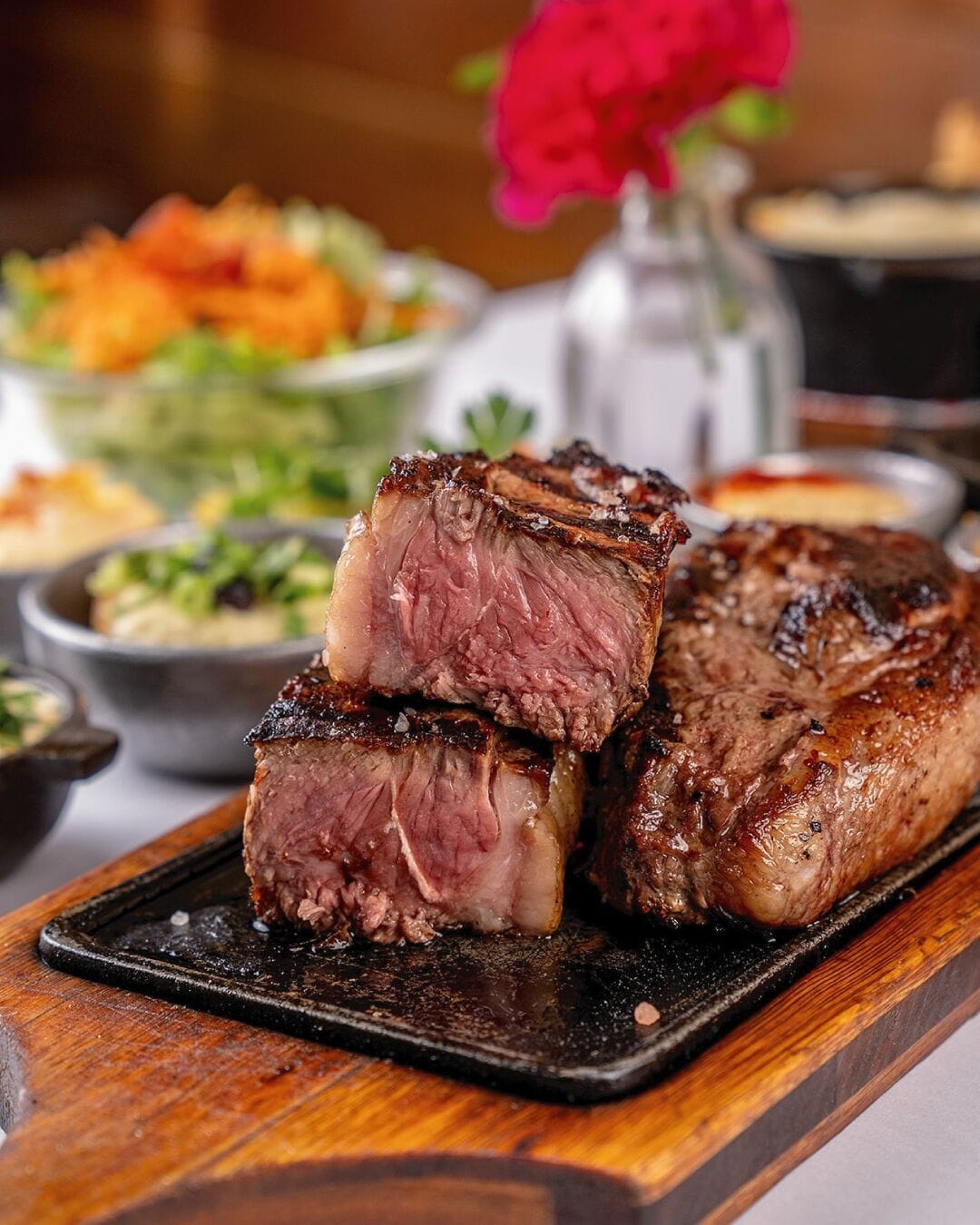 Bife com exterior chamuscado, servido em tábua de madeira.