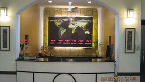 Uma mesa de recepção com um mapa-múndi, um relógio e uma placa com a palavra 'Angel'.
