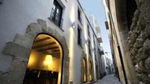 Uma rua estreita com edifícios que apresentam janelas em arco e fachadas de pedra.