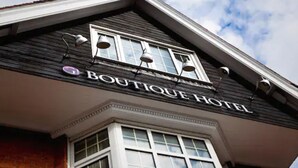 Um edifício com uma placa que diz "BOUTIQUE HOTEL" sobre a entrada.