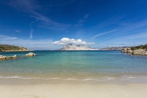 Perto da praia, espreguiçadeiras, guarda-sóis, toalhas de praia