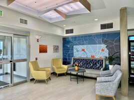 Um lobby moderno com assentos, um mural de mapa e uma máquina de vendas.
