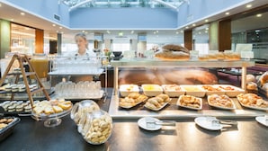 Buffet com diversos alimentos e uma vitrine de vidro.