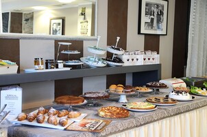 Um buffet com diversos doces, bolos e sobremesas.