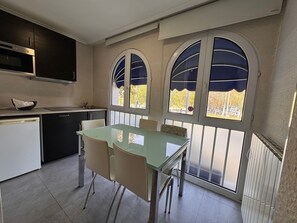 Uma cozinha moderna com área de refeições, grandes janelas e vista para o exterior.