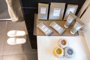 Uma toucador de casa de banho com um kit de higiene, touca de banho e vários artigos de higiene pessoal.