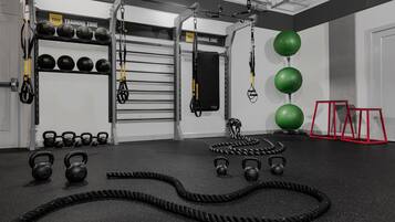 Academia com cintas TRX, kettlebells e bolas de exercício.