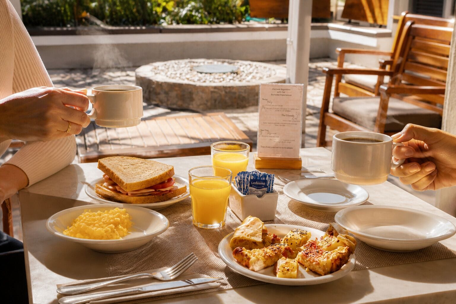 Mesa de café da manhã com torradas, ovos mexidos, suco de laranja e café.