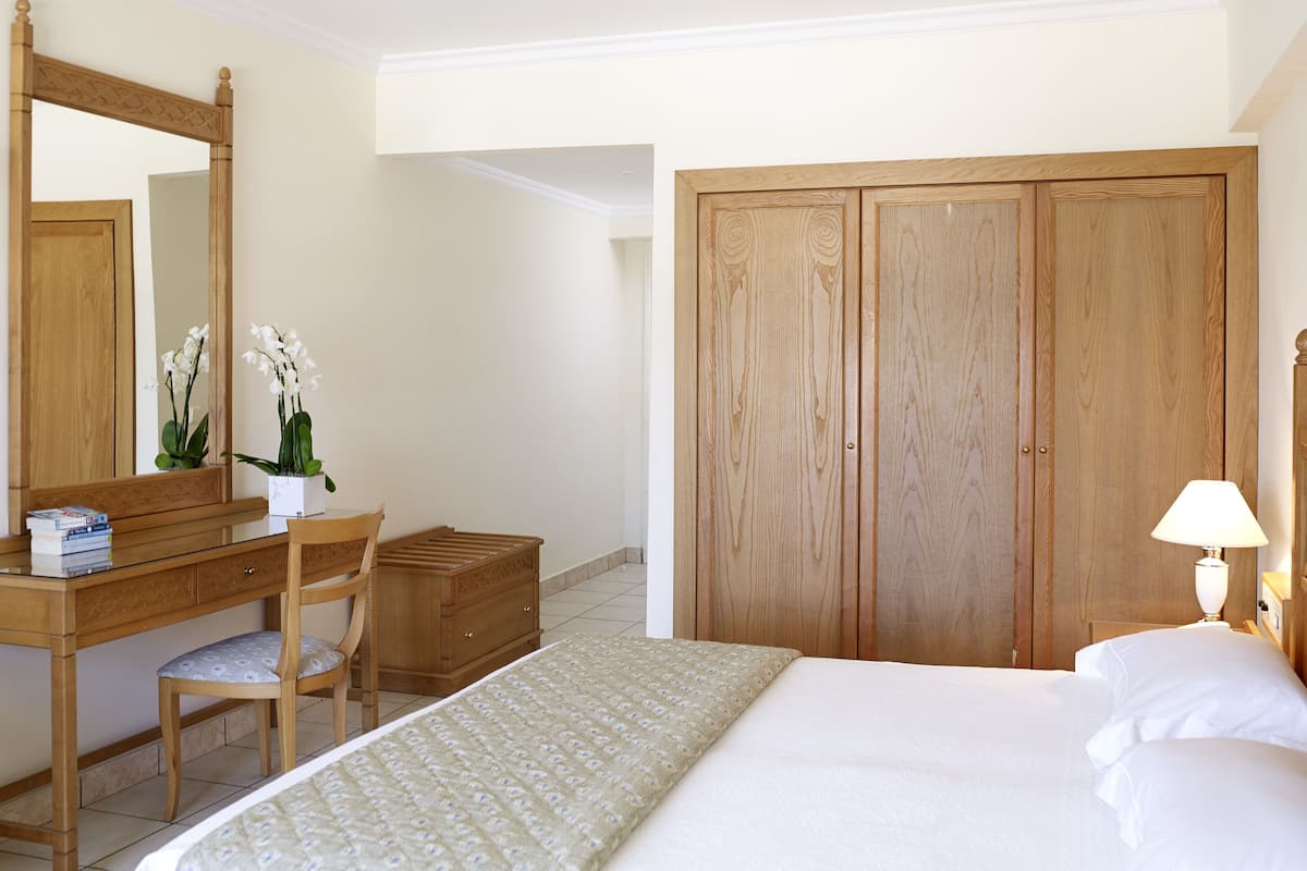 Quarto com escrivaninha de madeira, cadeira e guarda-roupa.
