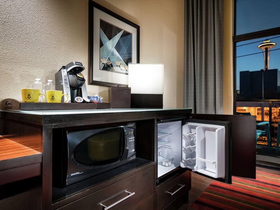 Quarto de hotel compacto com cozinha compacta, uma obra de arte emoldurada na parede e vista para a Space Needle.