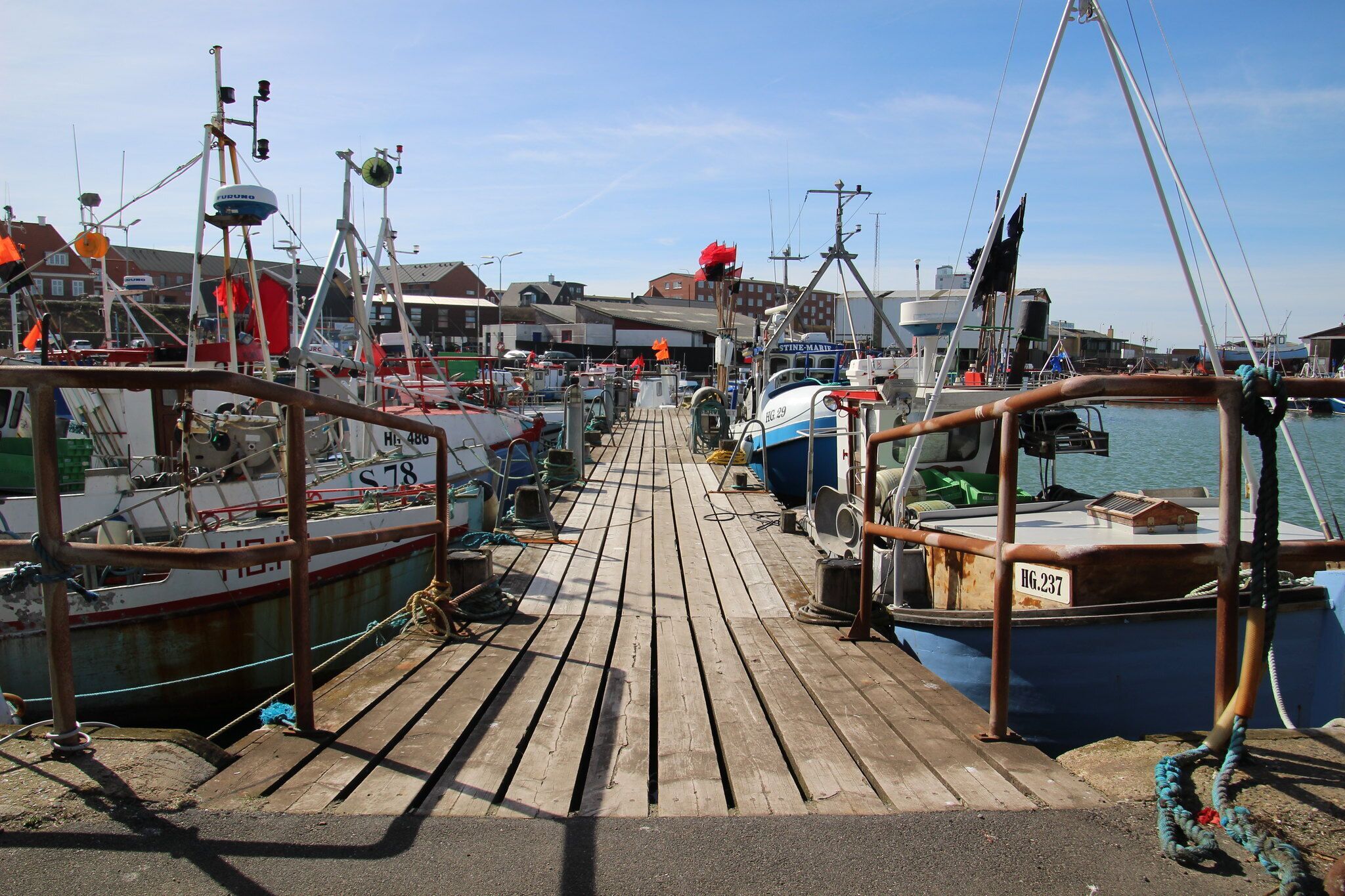 Um cais de madeira com vários barcos atracados em uma marina.
