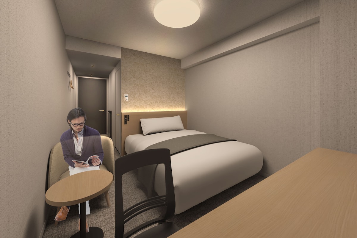Quarto de hotel moderno com cama, escrivaninha e cadeira.