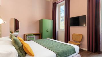 Um quarto com uma cama, um guarda-roupa verde, uma televisão e uma janela com cortinas.