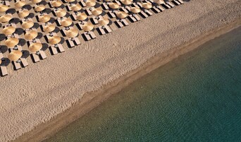 Na praia, praia de areia negra, espreguiçadeiras, guarda-sóis de praia