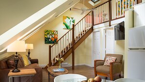 Uma sala de estar moderna com escada de madeira, mesa de jantar de vidro e um espaço de estar confortável.