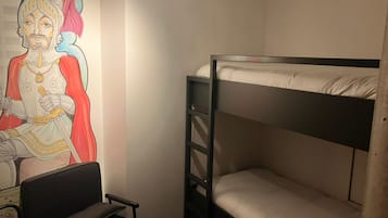Quarto com beliche e um mural na parede.