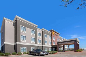 Um hotel La Quinta com design moderno, que conta com um amplo estacionamento e entrada coberta.