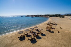 Perto da praia, espreguiçadeiras, guarda-sóis, toalhas de praia 