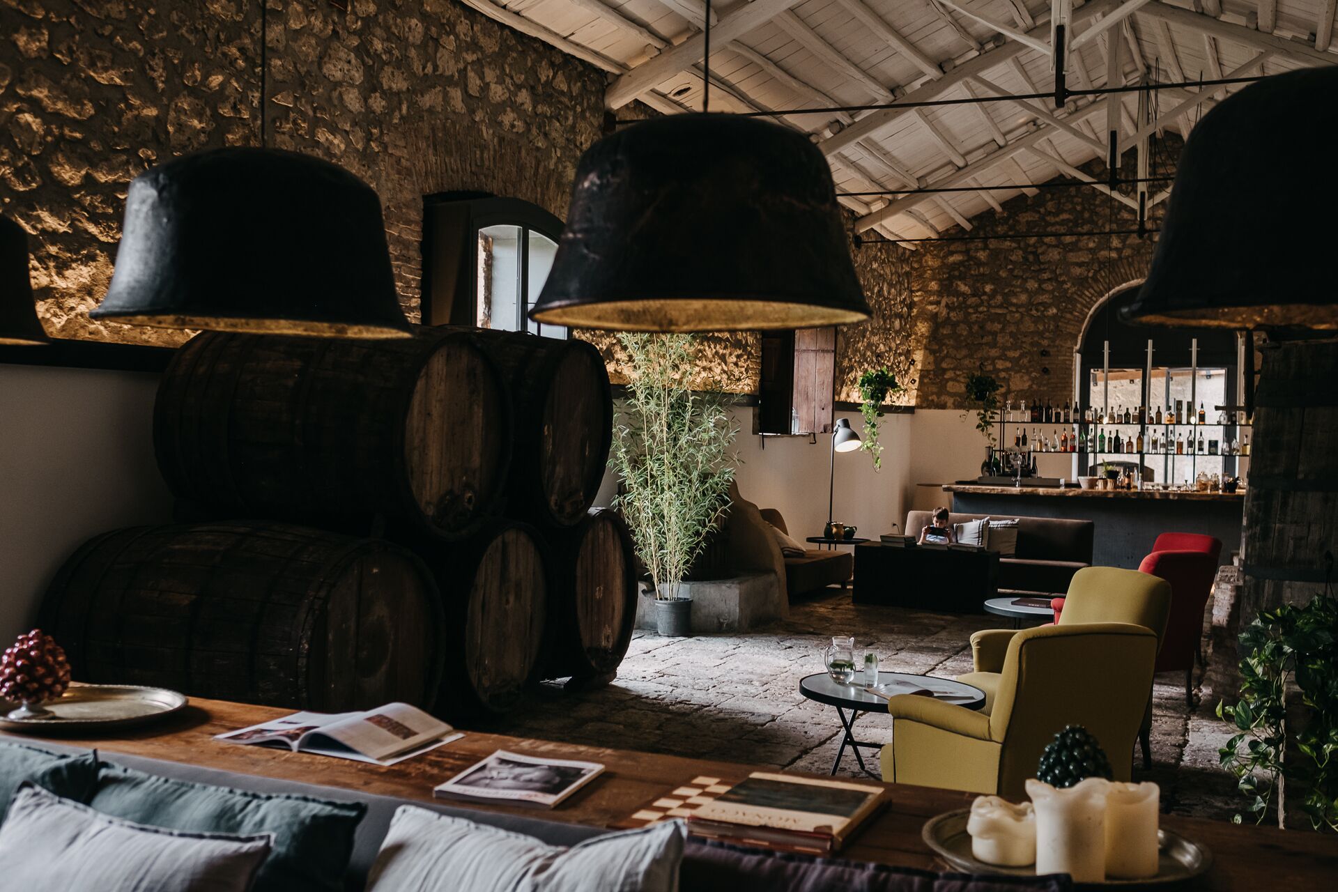 Um interior rústico com barris de madeira, área de bar e assentos.