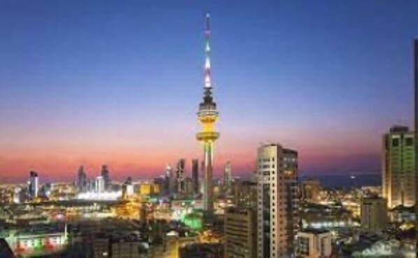 Paisagem urbana com uma torre imponente, provavelmente um ponto de referência, rodeada por edifícios modernos.