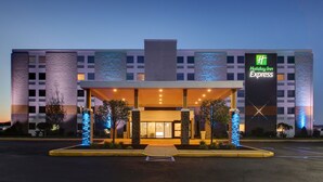 Um hotel Holiday Inn Express com fachada moderna, janelas amplas e entrada bem iluminada.