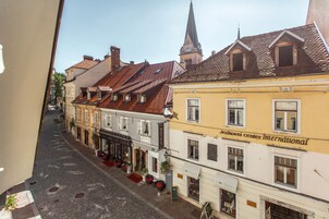 Vista da rua de uma cidade histórica, com edifícios com arquitetura tradicional, incluindo um hotel com a placa 'Hotel'.