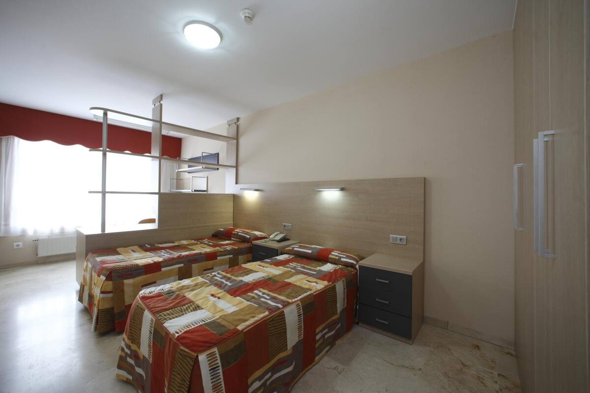 Quarto com beliches, escrivaninha e espelho.