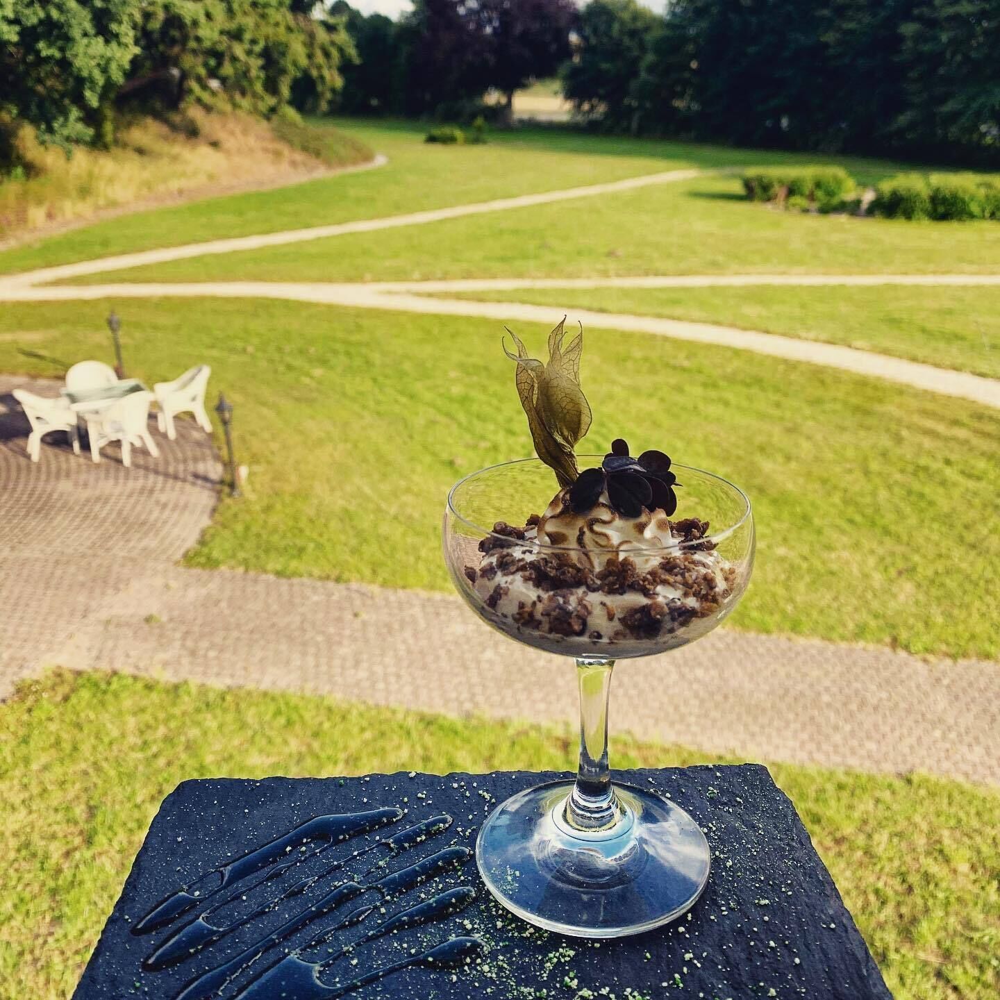 Sobremesa num copo sobremesa ao ar livre, com vista para um parque.