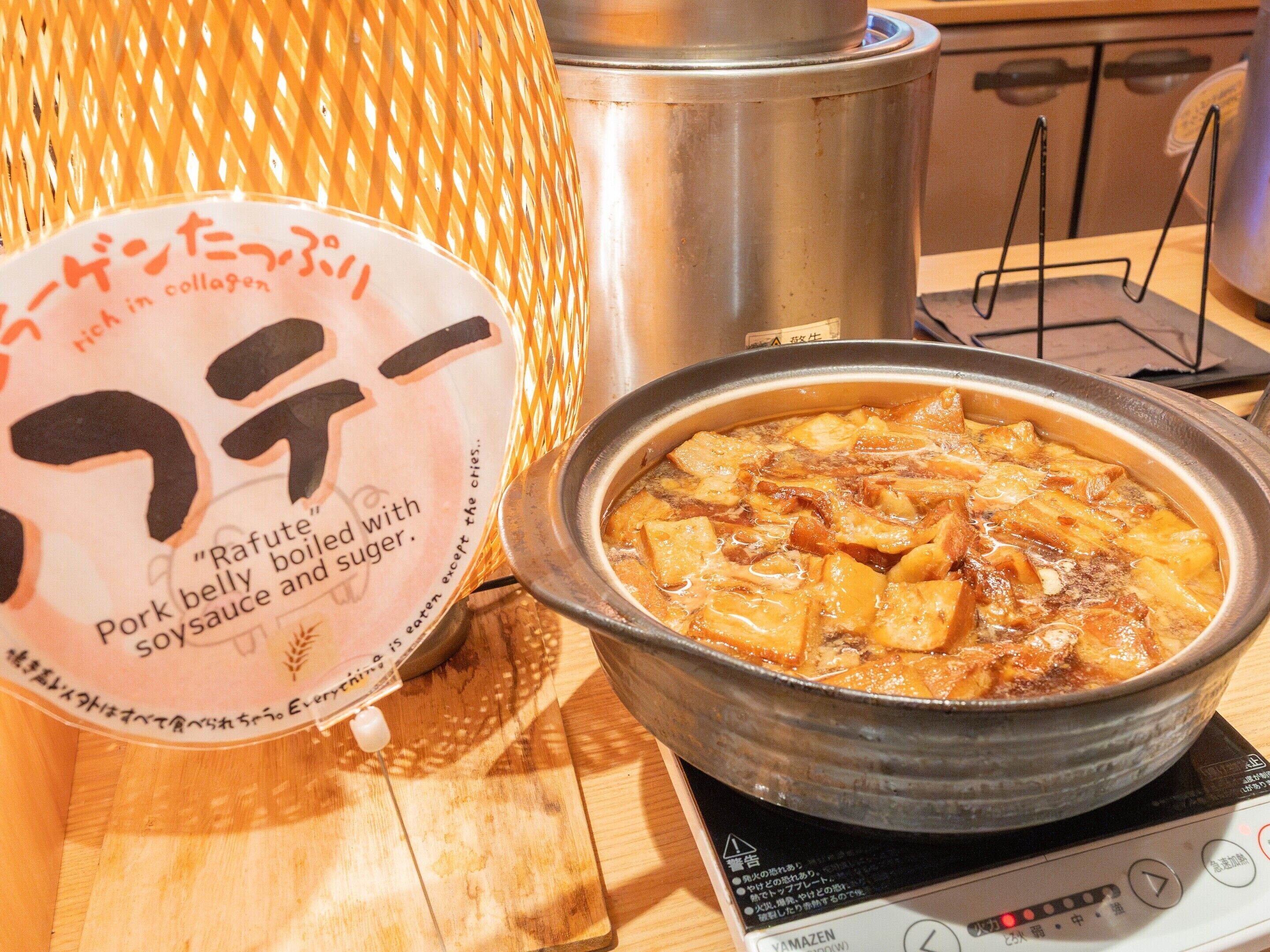 Uma cozinha com uma panela no fogão, um prato de comida e um cardápio.