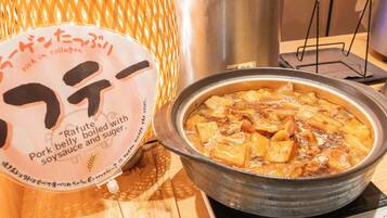 Uma cozinha com uma panela no fogão, um prato de comida e um cardápio.