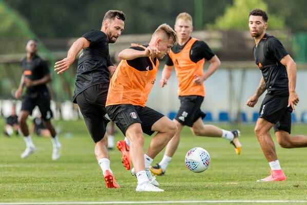 Um grupo de pessoas jogando futebol em um campo gramado.