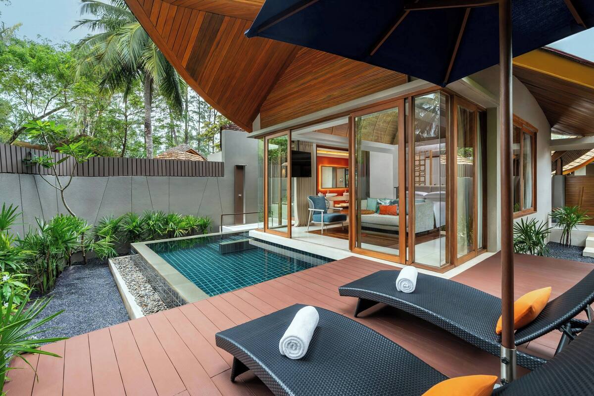 Uma área de piscina moderna ao ar livre, com espreguiçadeiras e um deck de madeira.