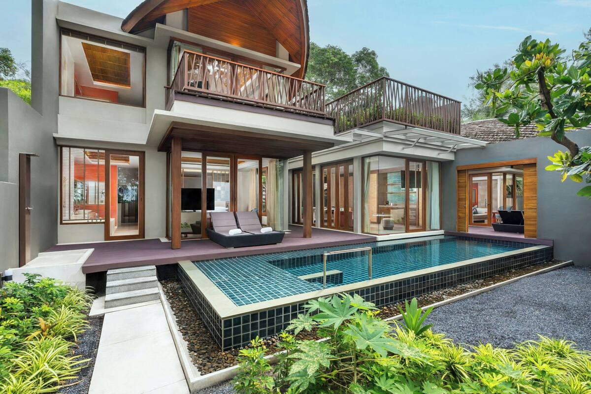 Uma casa moderna com piscina, área de estar externa e varanda coberta.
