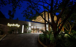 Um edifício moderno com uma placa que diz 'le petit village' à noite.