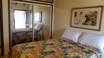 Quarto com uma cama grande, um espelho e um quadro na parede.