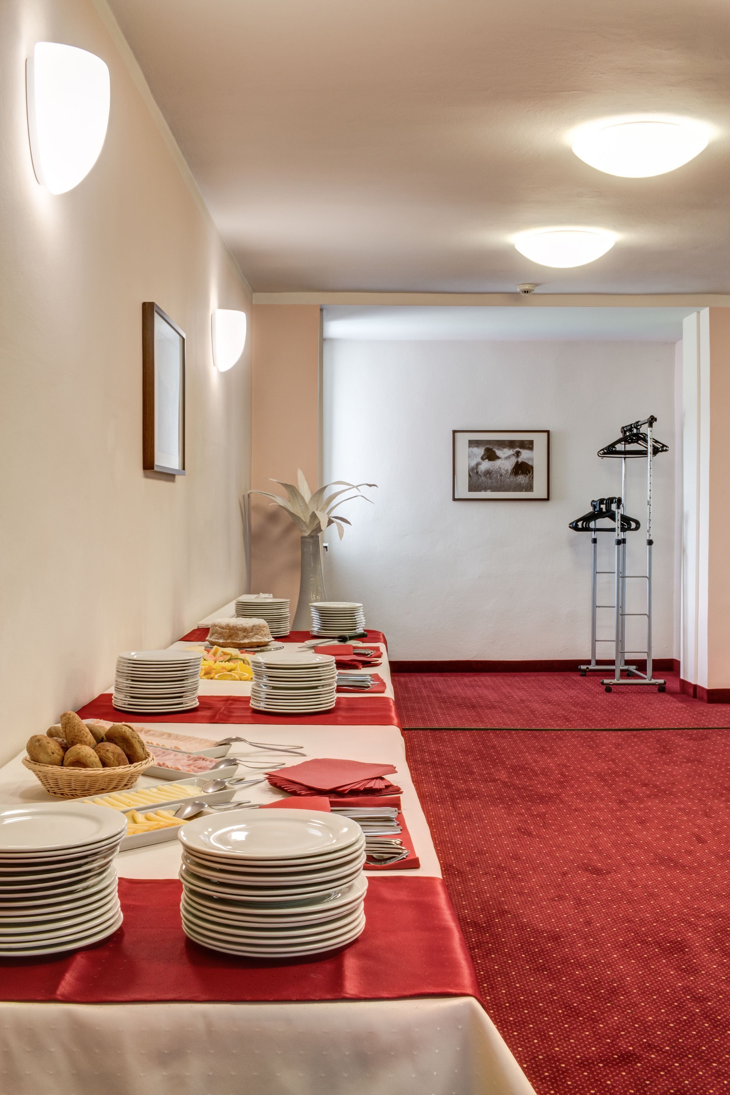 Uma sala de jantar com uma mesa comprida posta com pratos, talheres e uma cesta de pão.