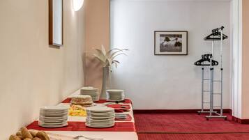 Uma sala de jantar com uma mesa comprida posta com pratos, talheres e uma cesta de pão.