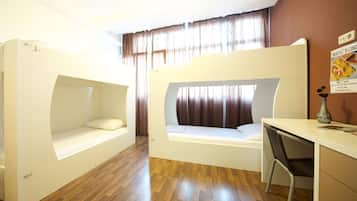 Um quarto com beliches, uma escrivaninha e uma cadeira.