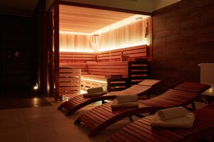 Uma sala de sauna com bancos de madeira, incluindo bancos com toalhas.