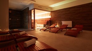 Uma sala de sauna com espreguiçadeiras de madeira, um banco e uma parede de madeira.