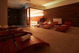 Uma sala de sauna com espreguiçadeiras de madeira, um banco e uma parede de madeira.